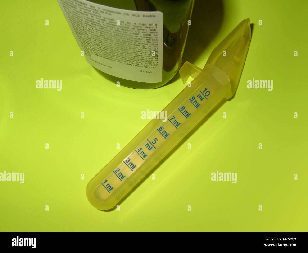 Medicine spoon with measuring scale next to a bottle of cough syrup ...