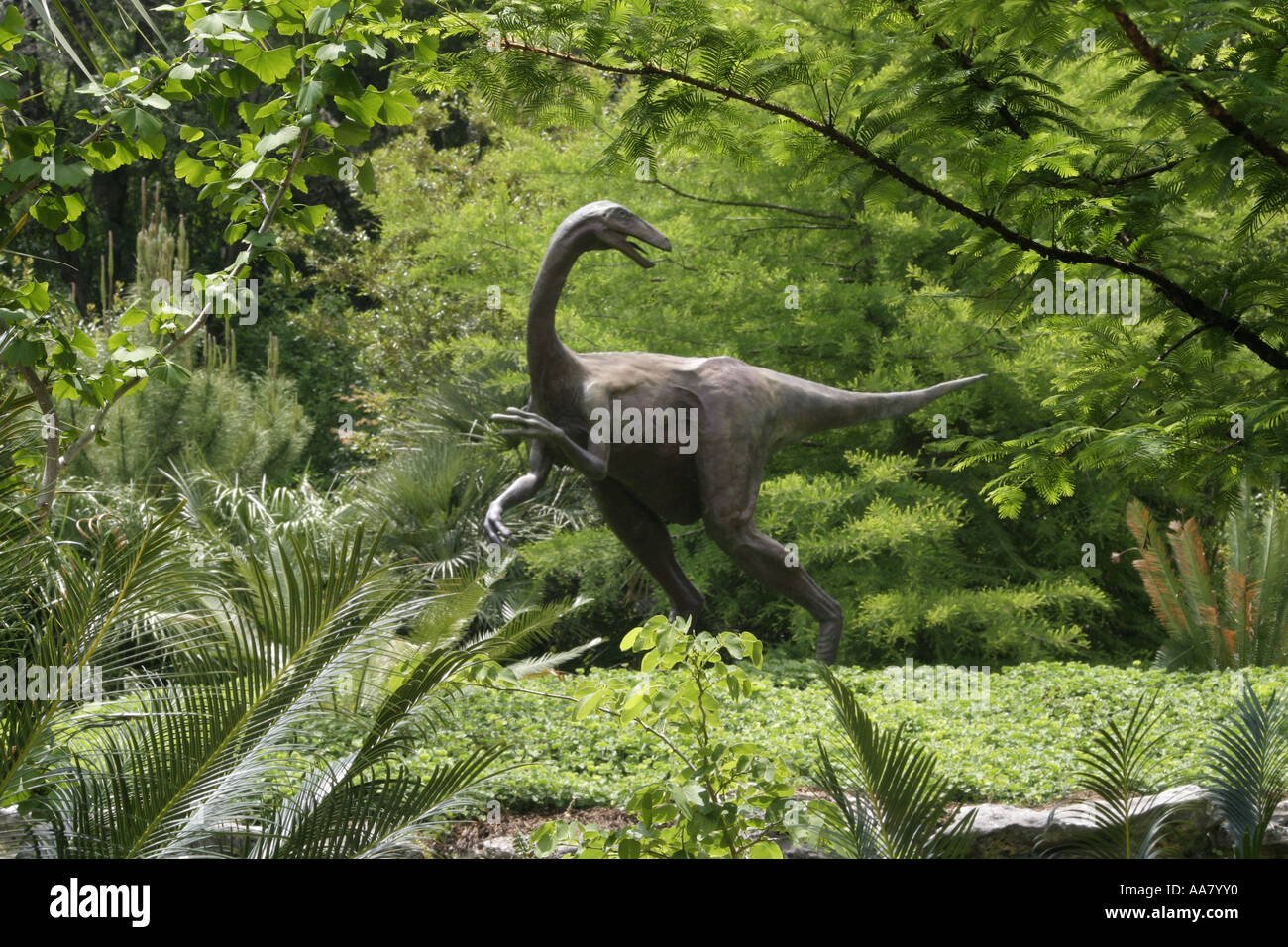 A raptor dinosaur sculpture appears to creep through the prehistoric ...