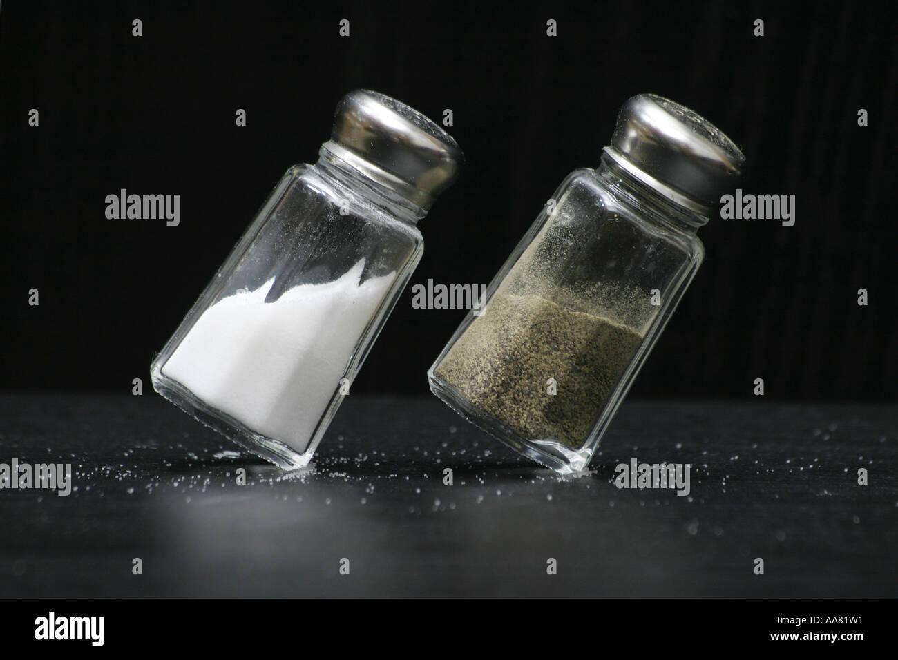 Salt and Pepper shakers bancing on edge Stock Photo - Alamy