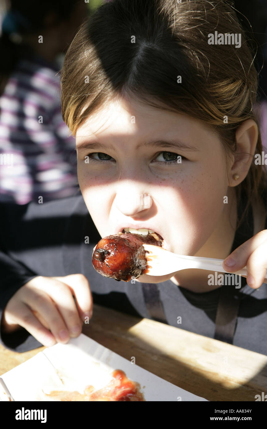 Girl eating sausage Stock Photo - Alamy