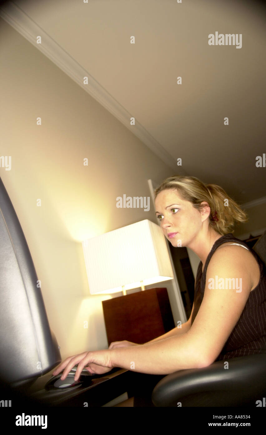 Vertical color image of an adult female sitting a computer workstation ...