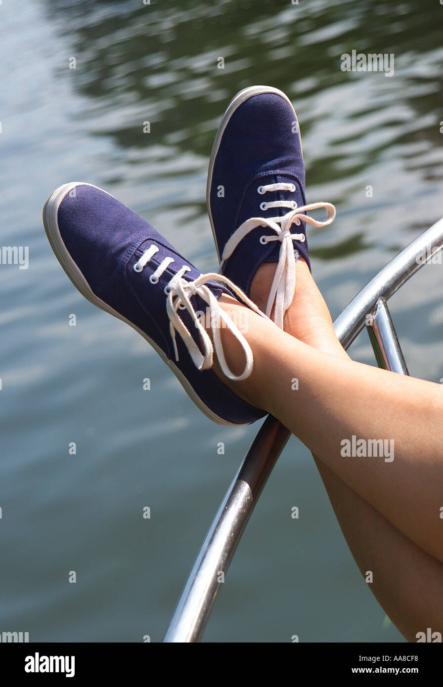 blue deck shoes and legs resting on boat railing Stock Photo - Alamy