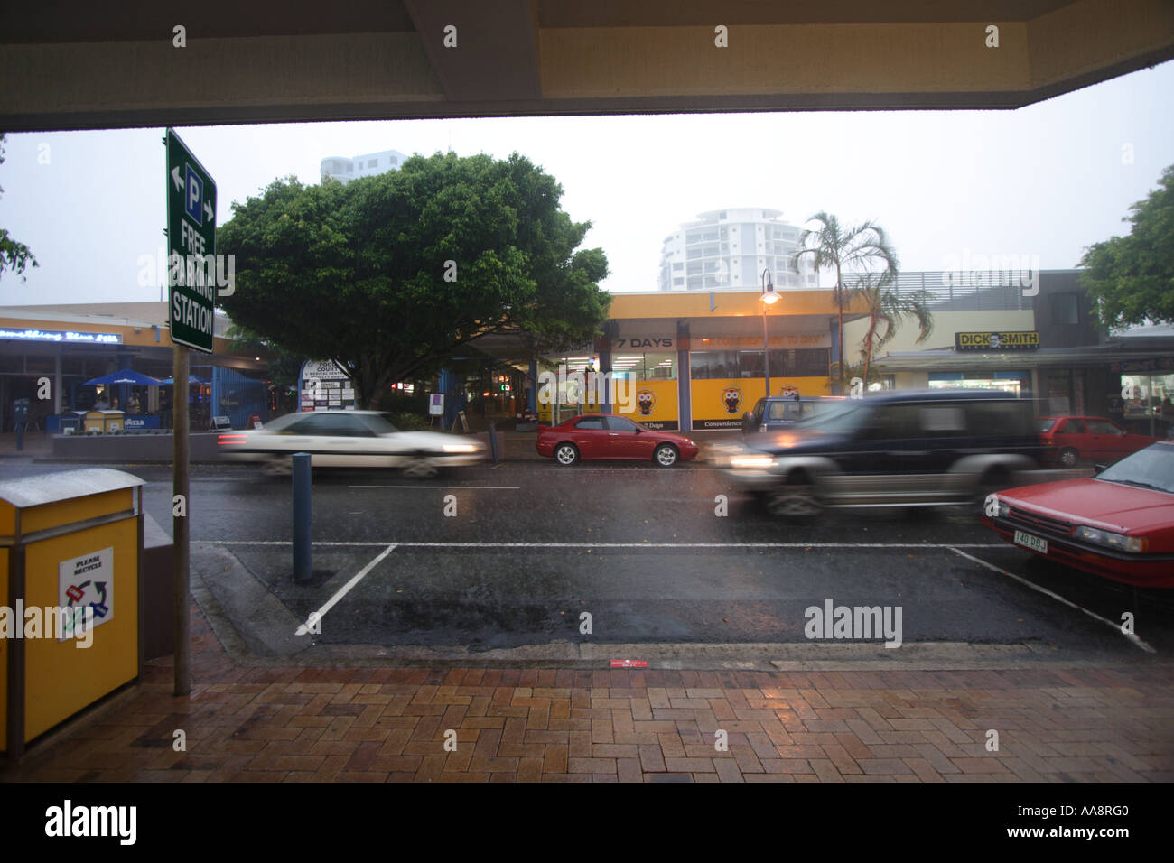 CARS DRIVING ALONG A SUBURBAN STREET QUEENSLAND AUSTRALIA HORIZONTAL ...