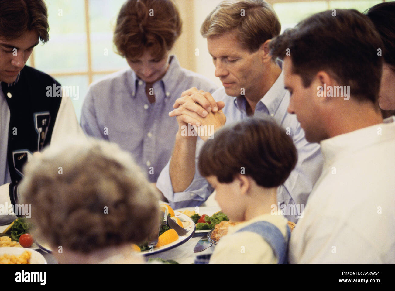 Young people praying at a table hi-res stock photography and images - Alamy