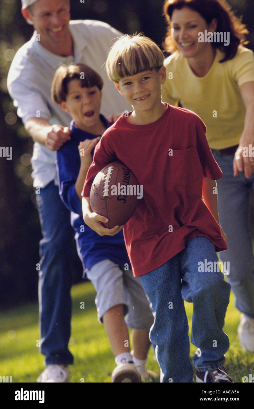 Couple playing football with their sons Stock Photo - Alamy