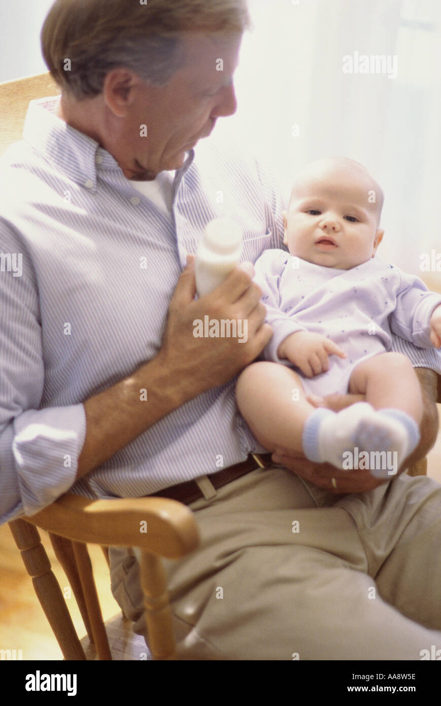 Close up of a man sitting in a rocking chair with a baby Stock Photo ...