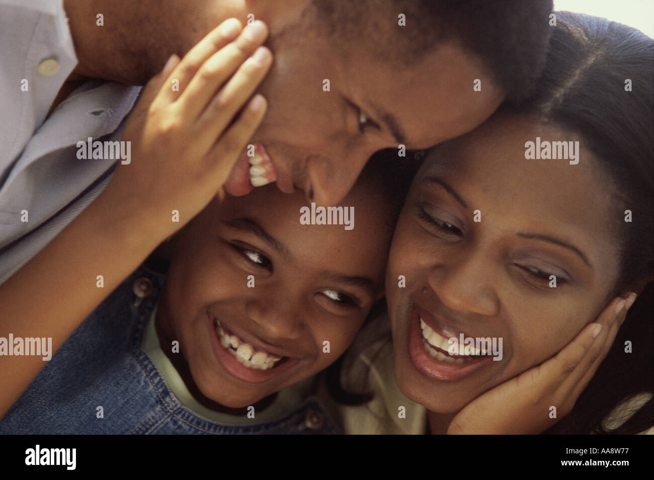 Close up of parents and their daughter smiling Stock Photo - Alamy