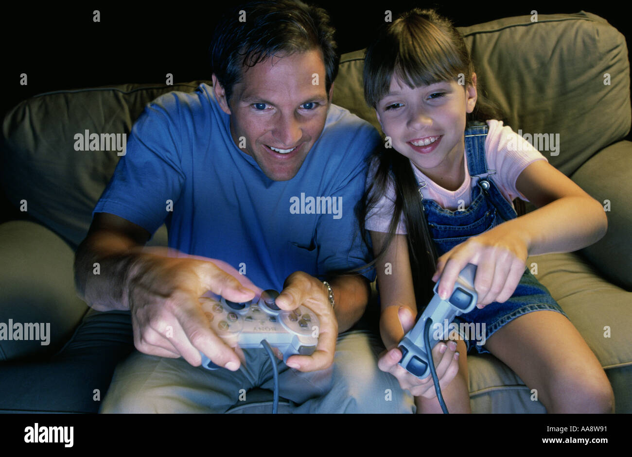 Father and daughter playing a video game together Stock Photo - Alamy