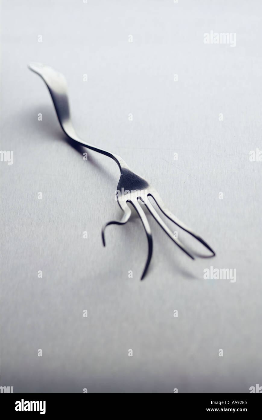 Artistic bent fork on light background with shadows and hi lights ...