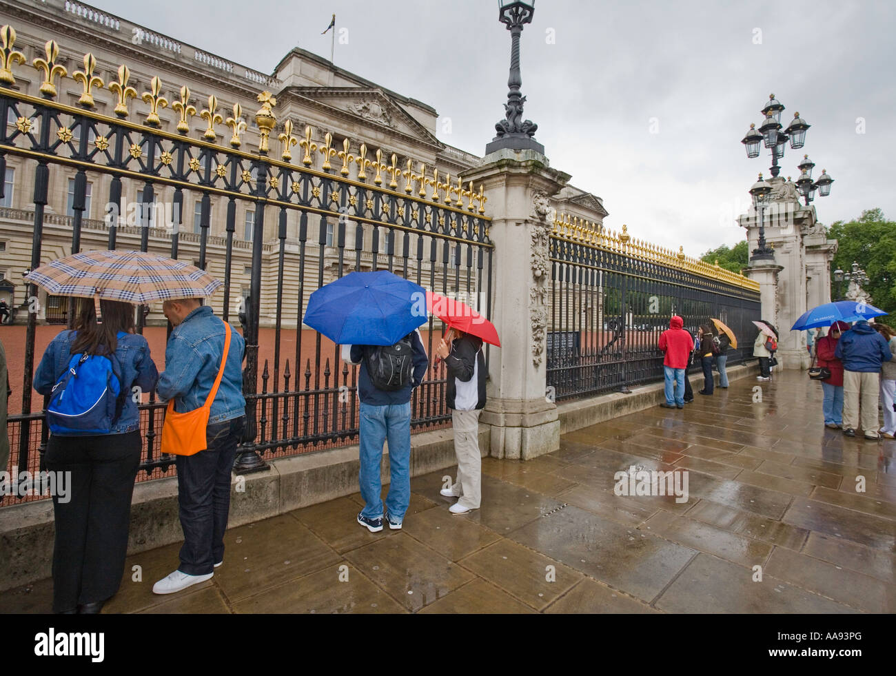 Tourists outside Buckingham palace on a rainy day London England UK ...
