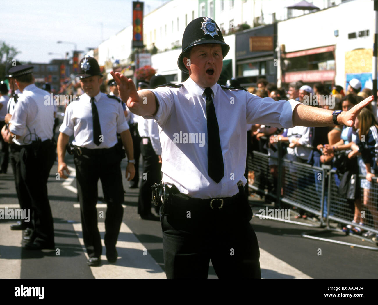 Policeman stopping traffic and directly crowds at Notting Hill Festival ...