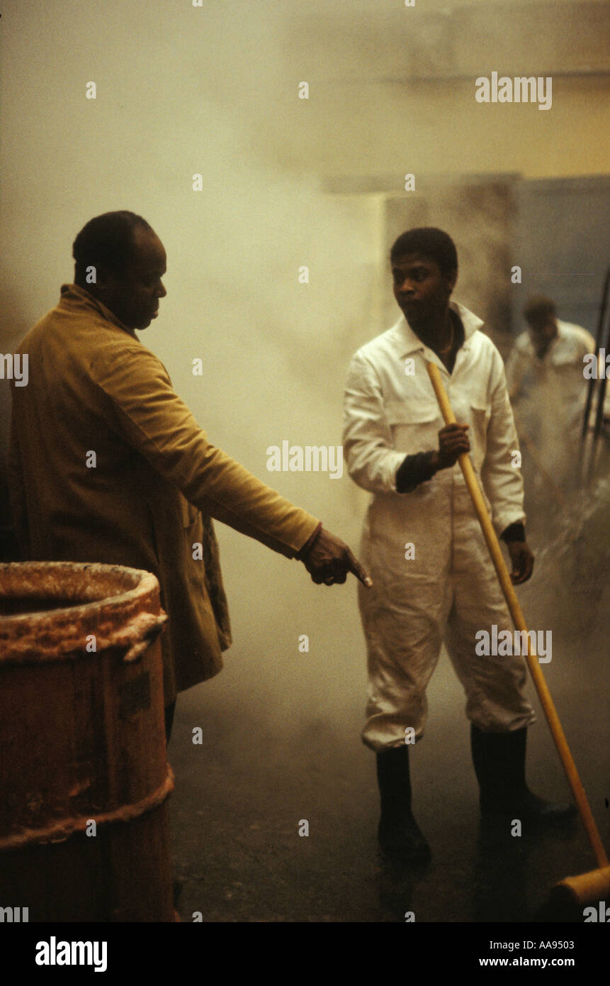 Factory worker being directed by his boss to clean up after the days ...