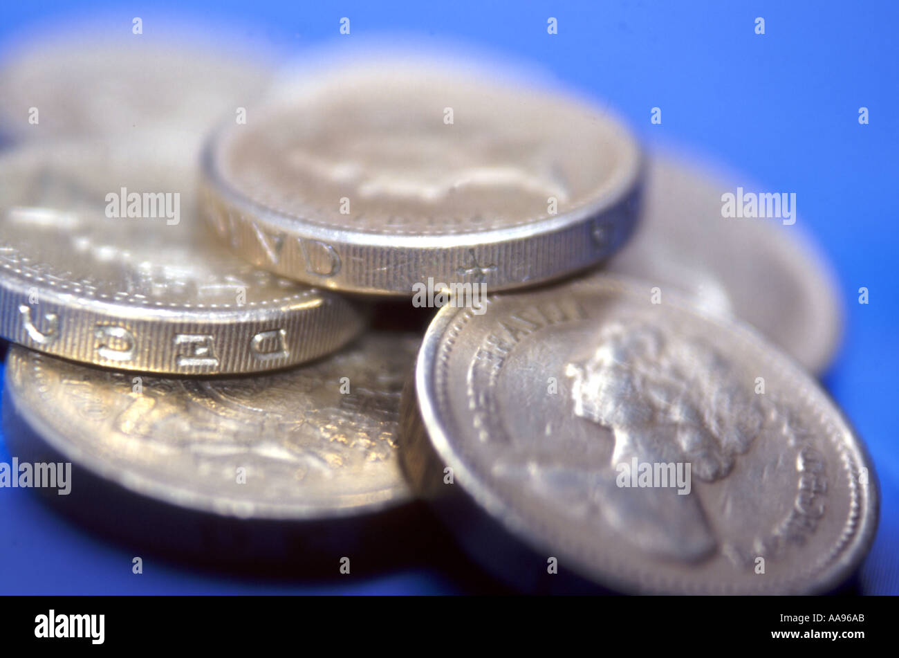 Group of one pound coins on blue background Stock Photo - Alamy