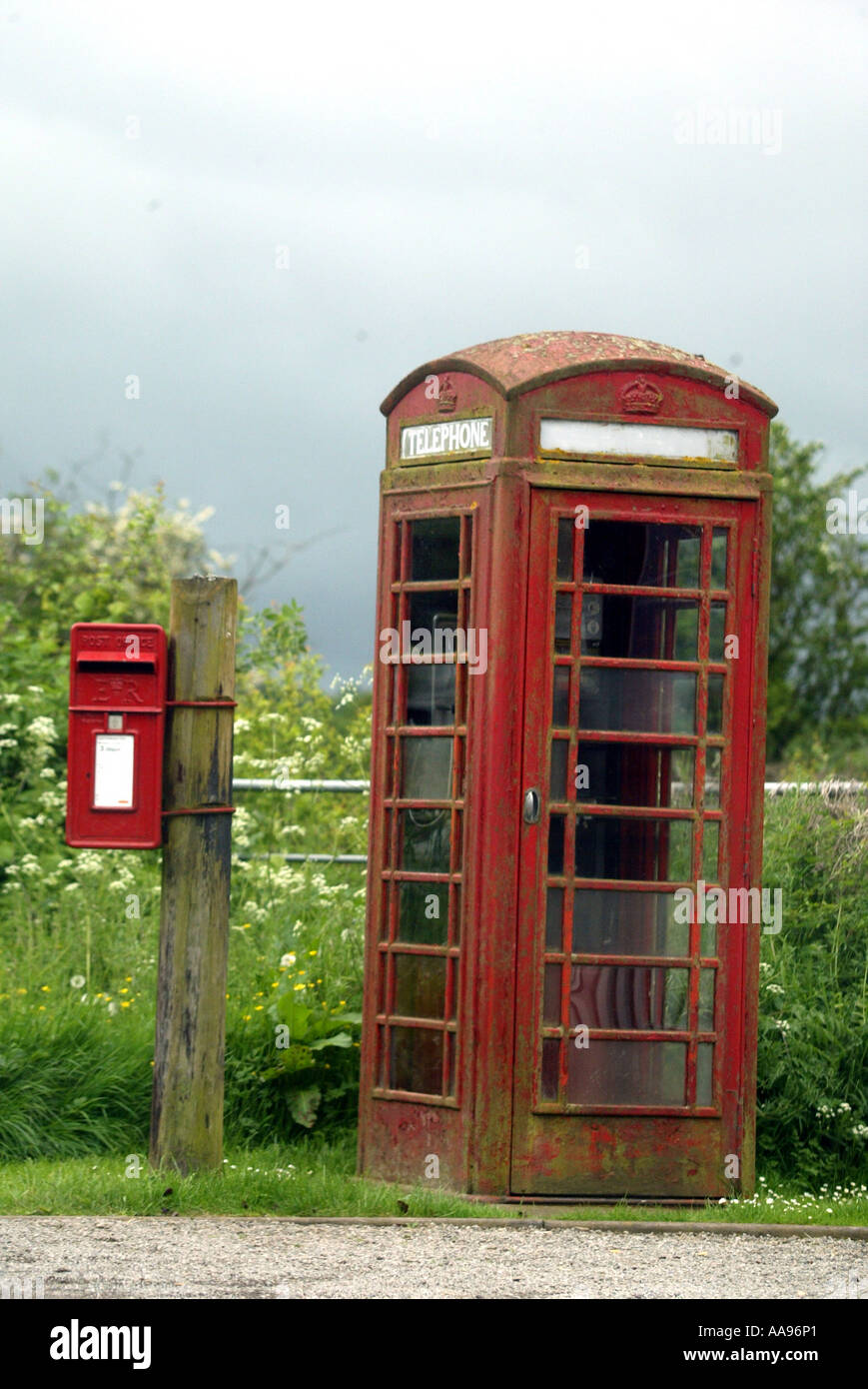 A TATTY RED TELEPHONE BOX STANDS NEXT TO A RED LETTER BOX IN ENGLAND ...