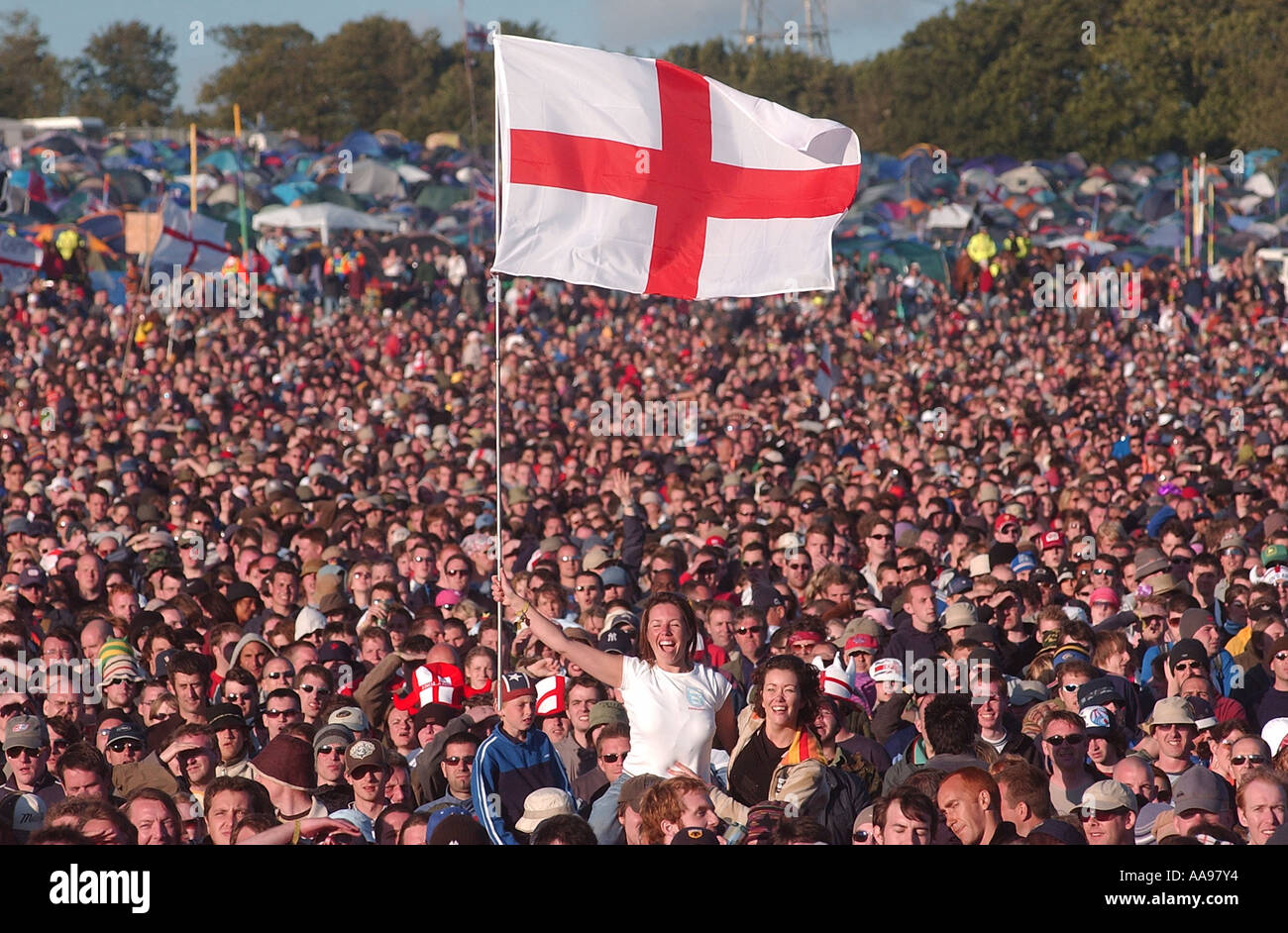 TWO SMILING AND CHEERING GIRLS SAT ON THEIR BOYFRIENDS SHOULDERS HOLD ...