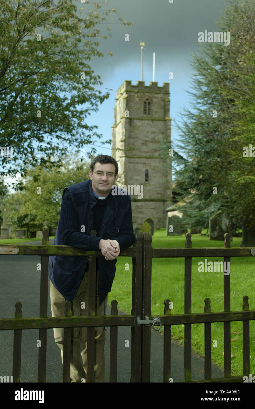 A COUNTRY VICAR LEANS ON THE GATE TO THE CHURCHYARD Stock Photo - Alamy