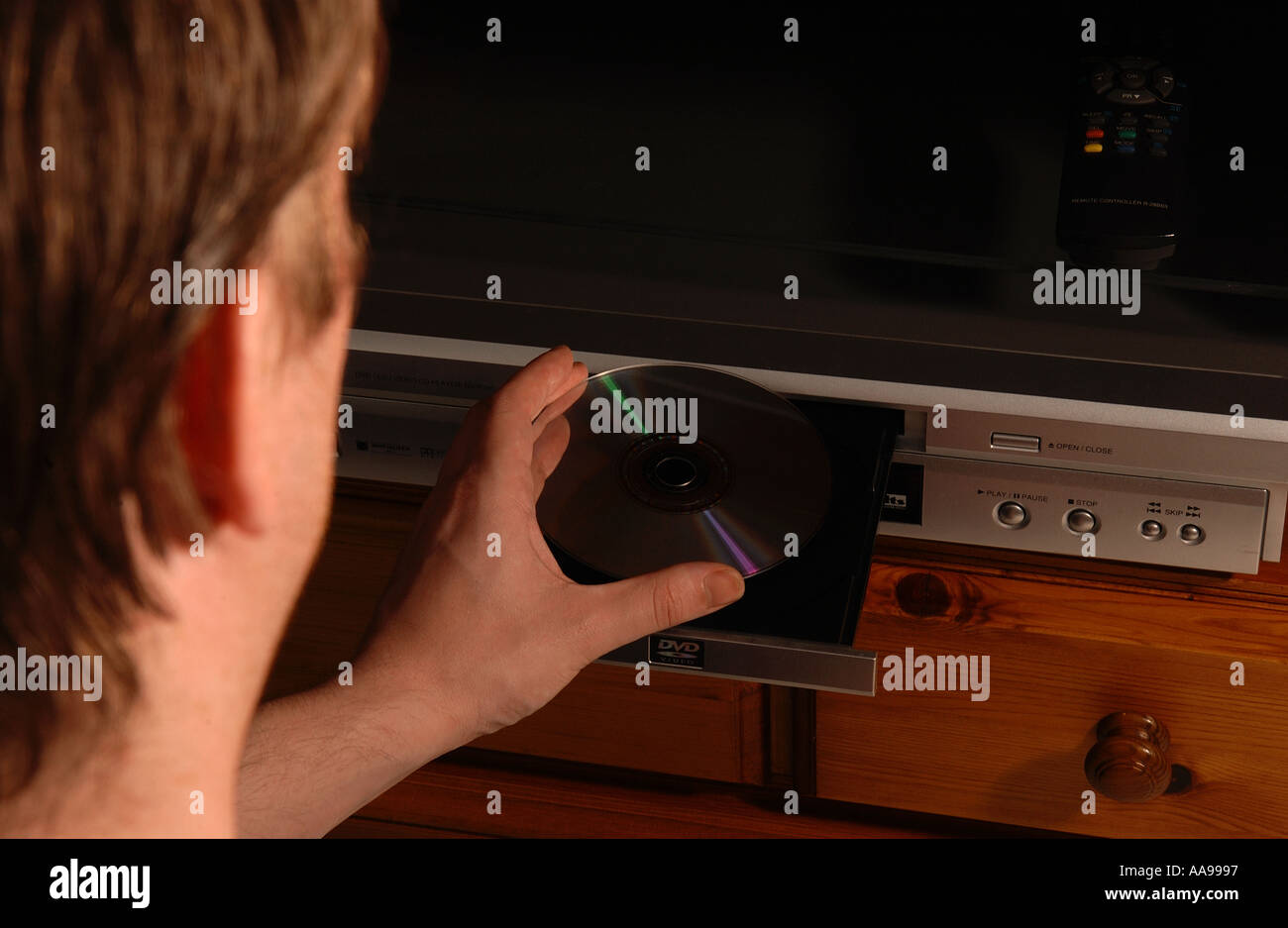 man putting dvd disc into dvd player Stock Photo - Alamy