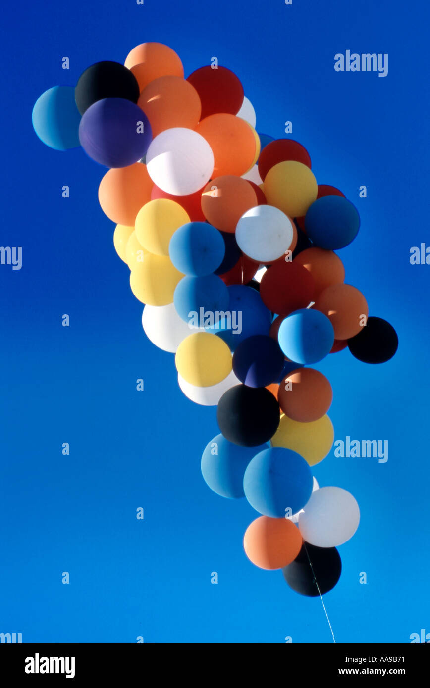 Group of colorful birthday balloons floating in blue sky Stock Photo ...
