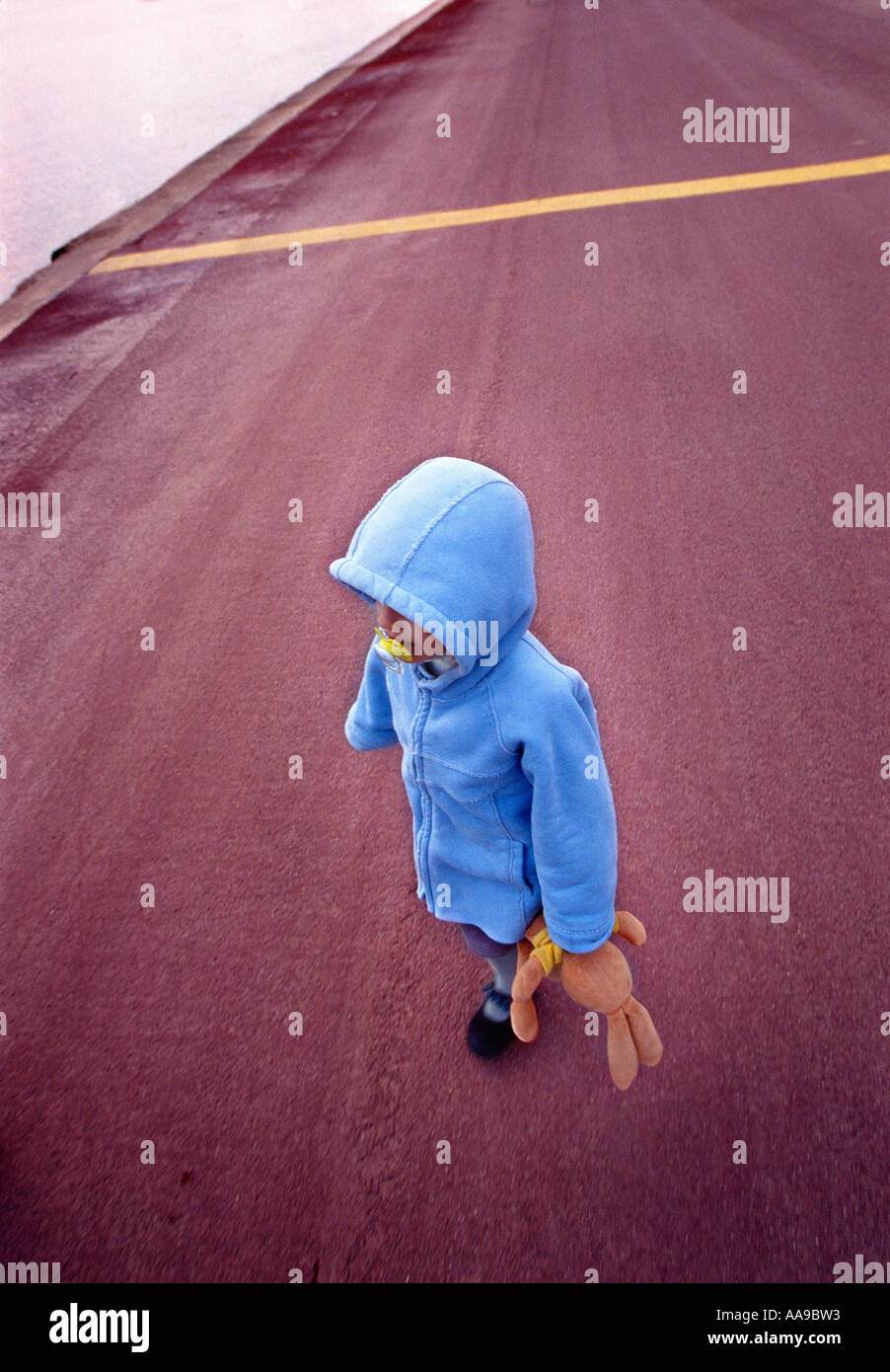little girl wearing blue toque walking on red tarmac Stock Photo - Alamy