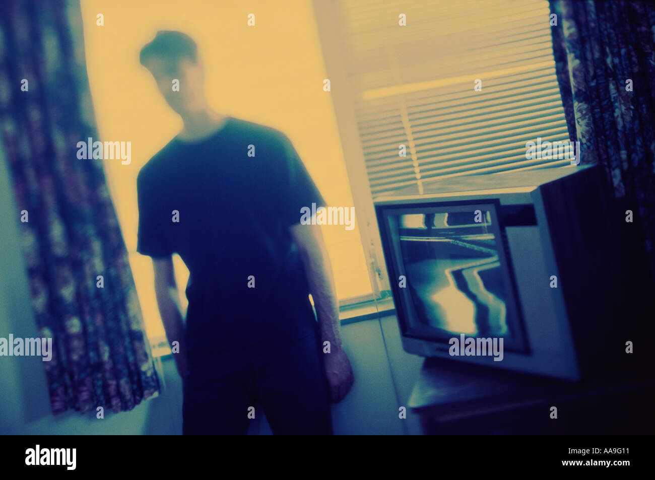 Young man standing beside a television Stock Photo - Alamy