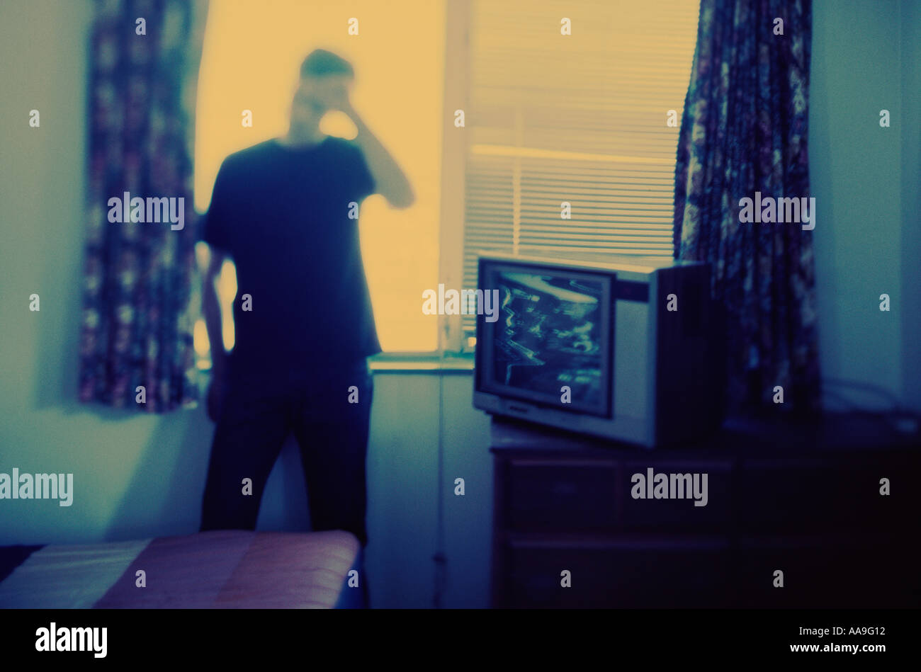 Young man standing beside a television Stock Photo - Alamy