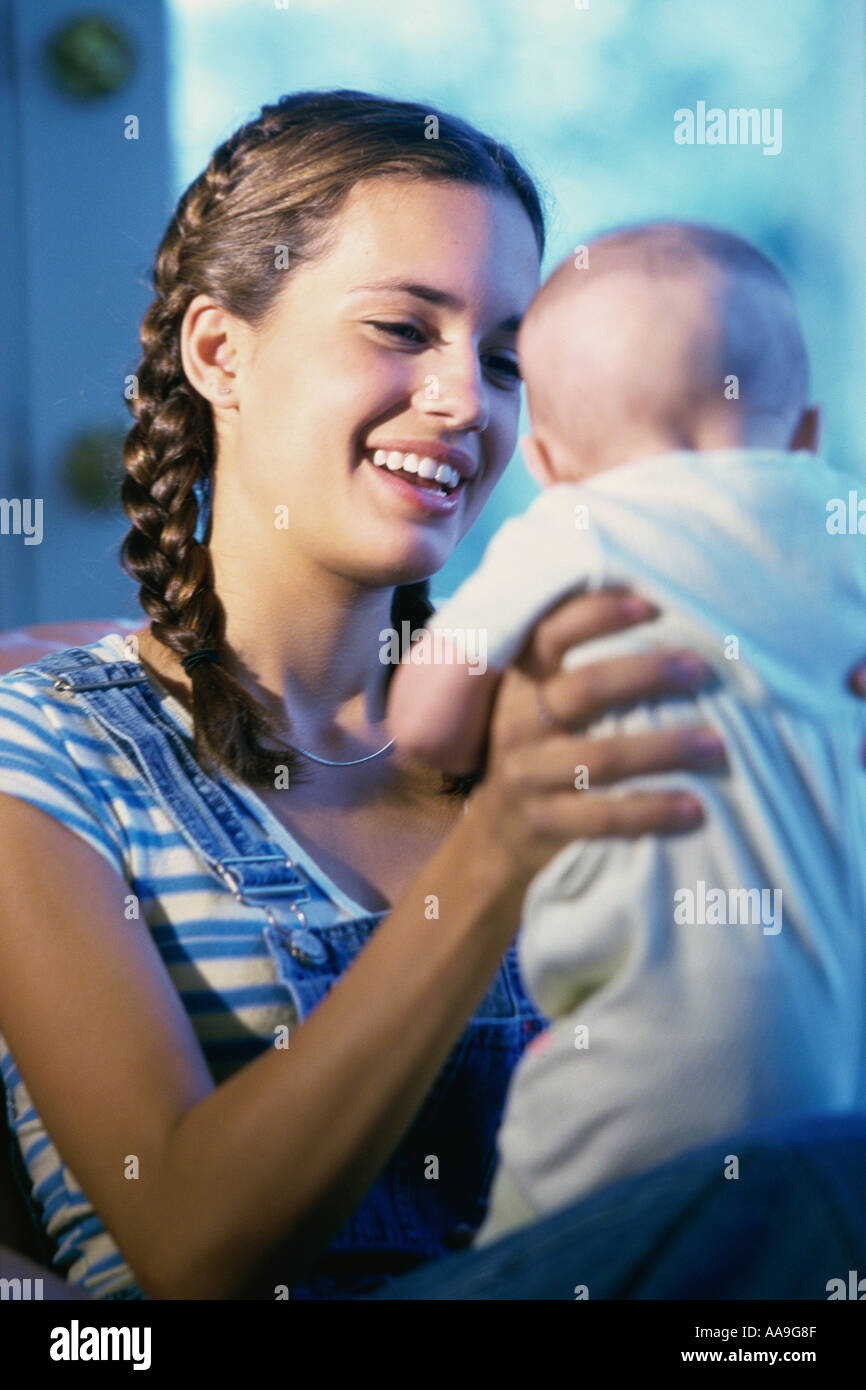 Teenage girl holding a baby Stock Photo - Alamy