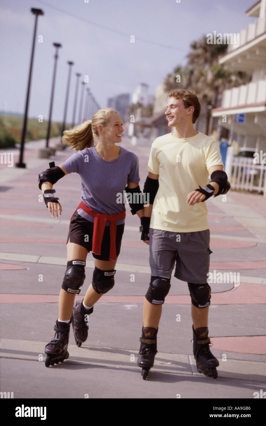 Young couple holding hands in line skating Stock Photo - Alamy