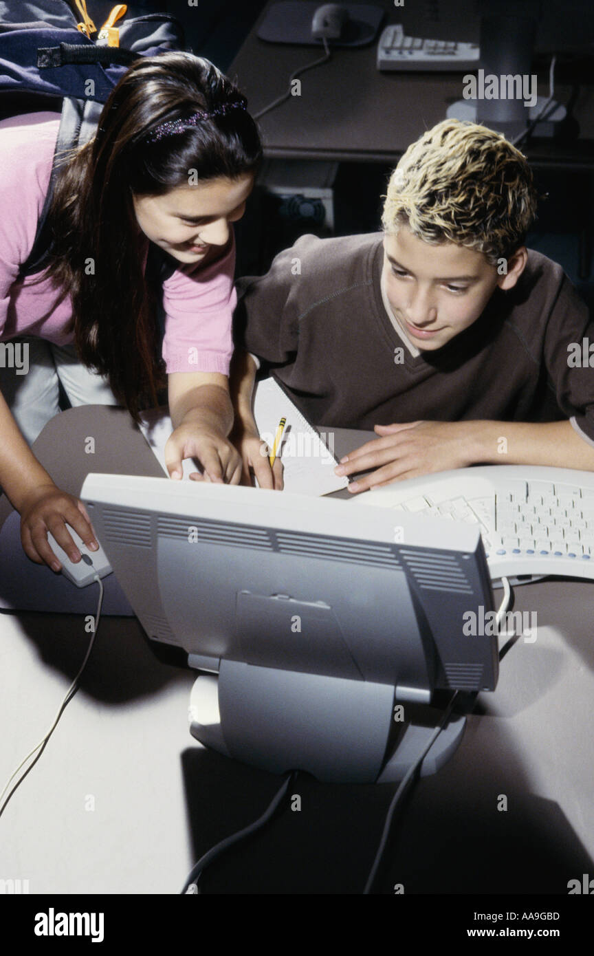 Teenage boy and a teenage girl in front of a computer monitor Stock ...