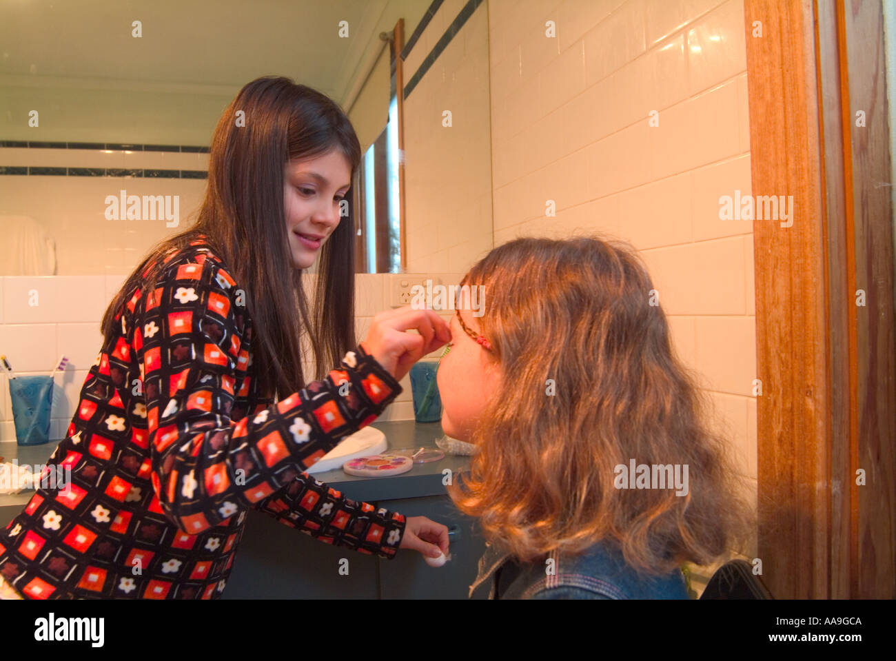 Two pretty 9 year old girls playing at putting on makeup Stock Photo ...