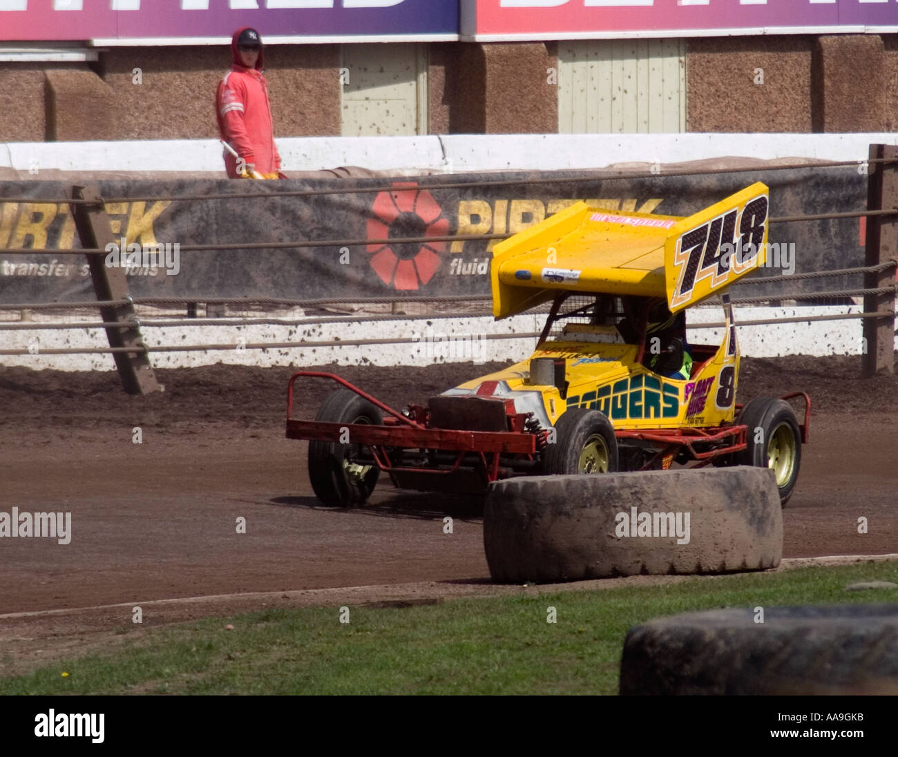 single yellow stock car drifting around a dirt circuit Stock Photo - Alamy