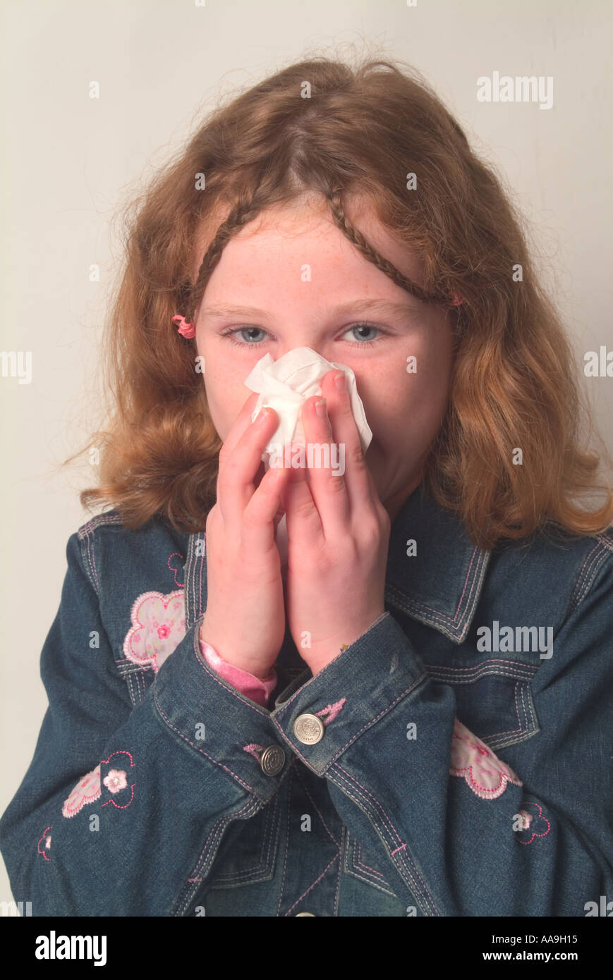 Young girl blowing her nose Stock Photo - Alamy