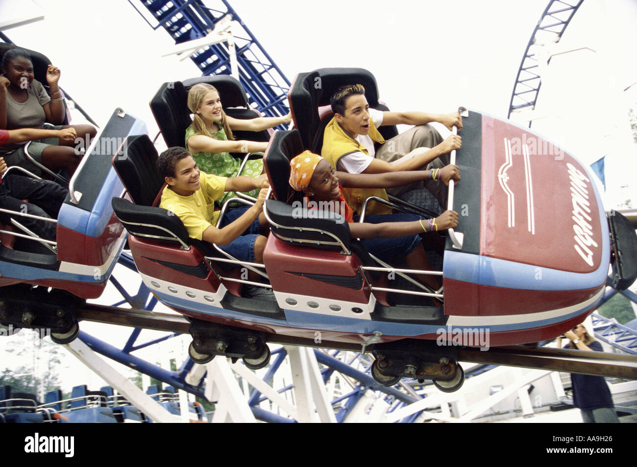 High angle view of teenage boys and girls on a roller coaster ride ...