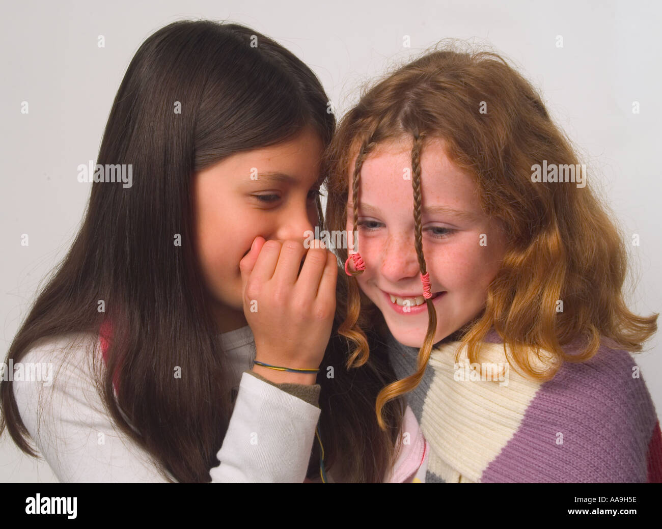 Two pretty nine year old girls sharing secrets Stock Photo - Alamy