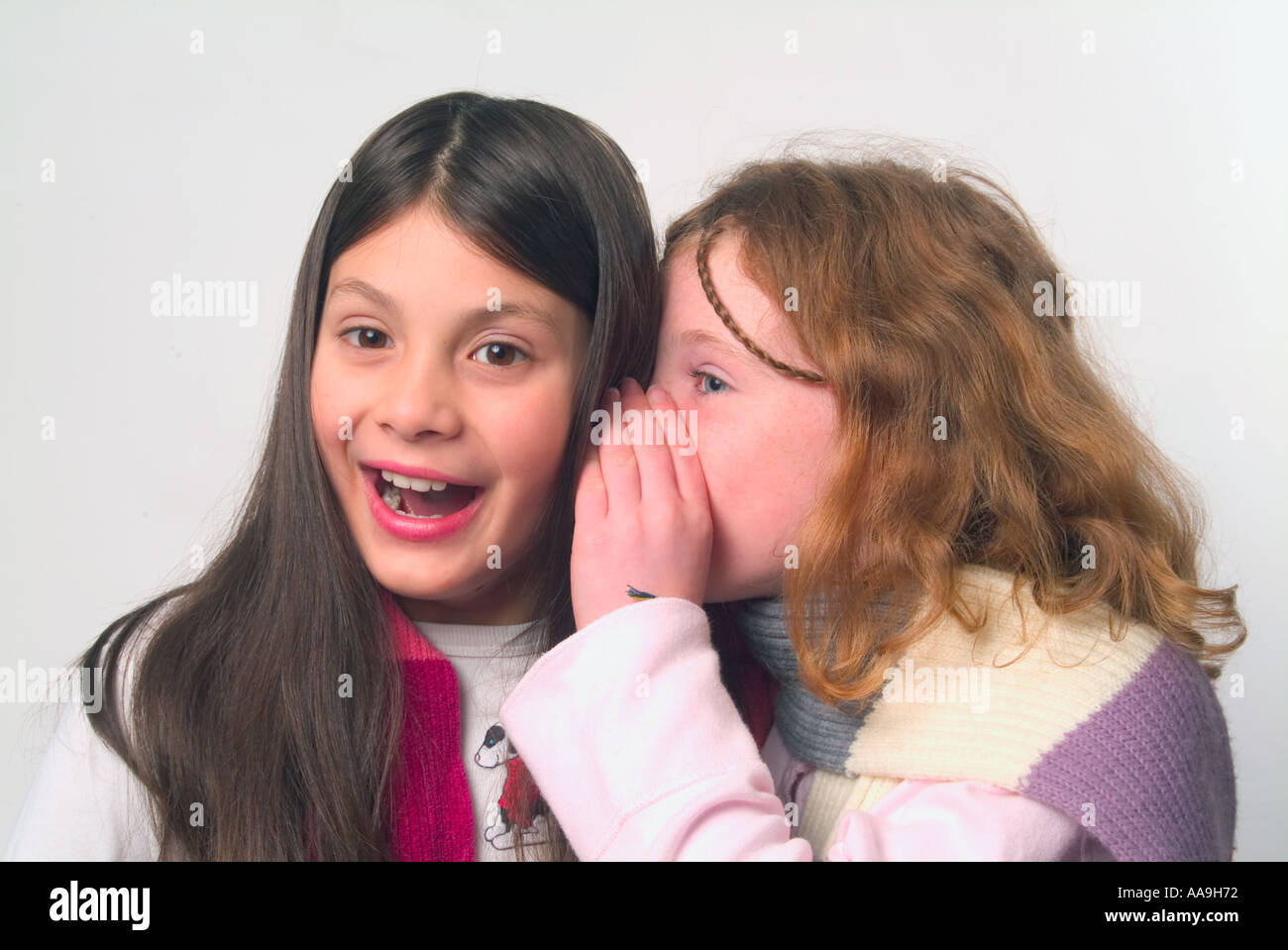 Two smiling girls sharing secrets hi-res stock photography and images ...