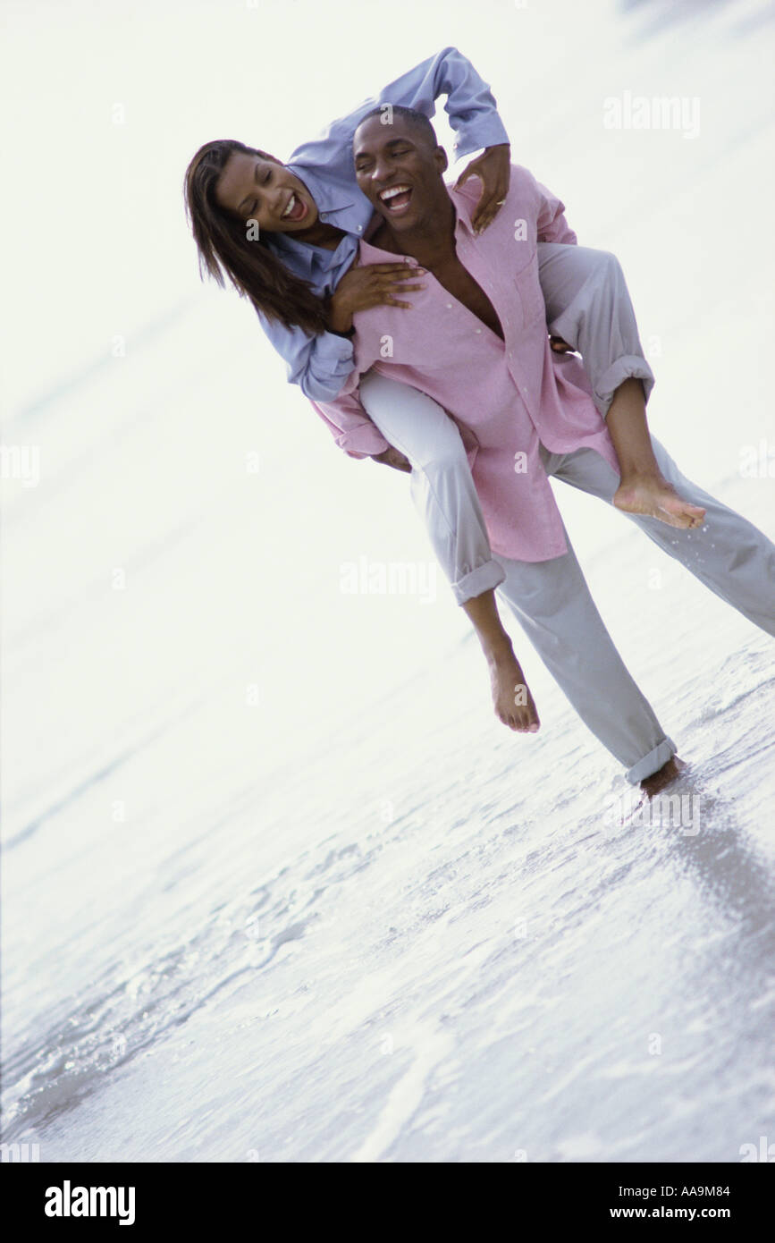 Young woman riding piggyback on a young man Stock Photo - Alamy