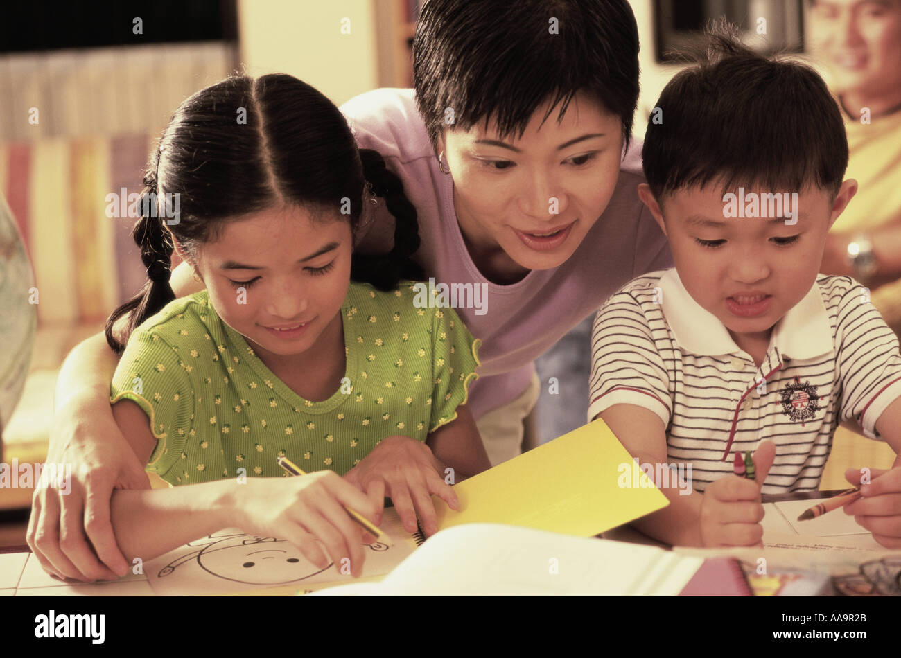 Mother and her two children studying Stock Photo - Alamy