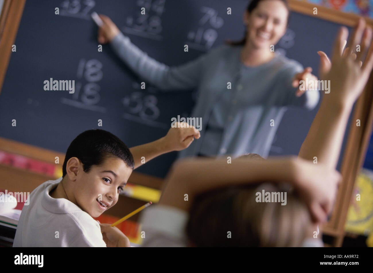 Students with their arms raised and a female teacher standing at the ...