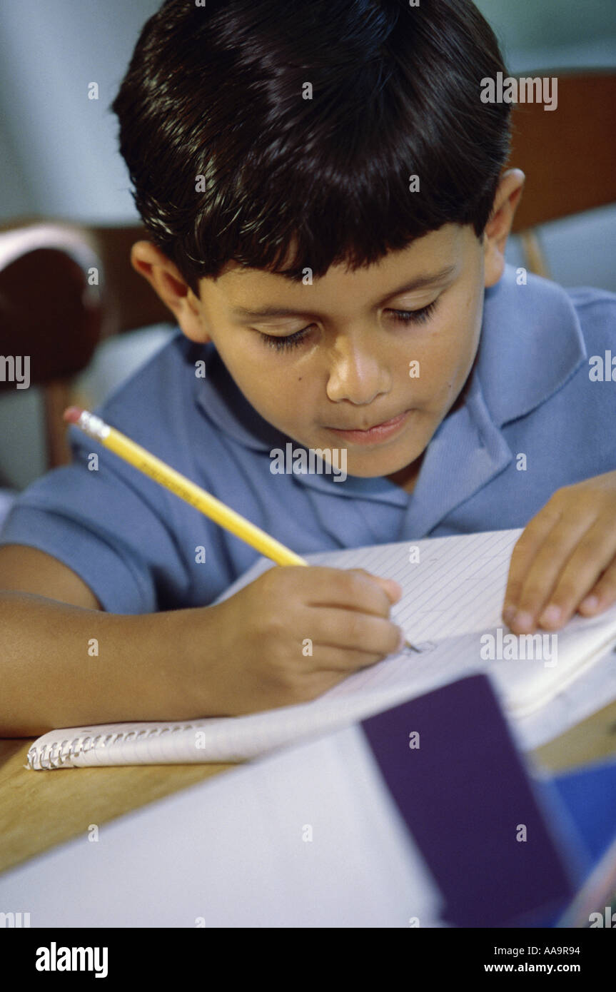 Boy writing with a pencil in a book Stock Photo - Alamy