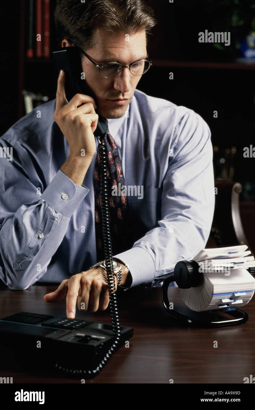 Young businessman using a landline telephone on his desk Stock Photo ...