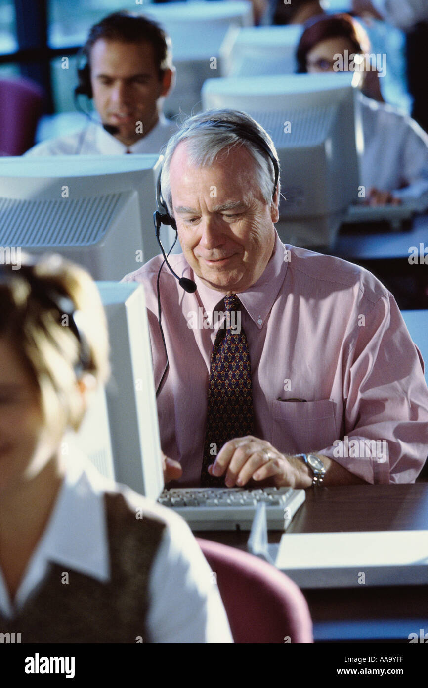 Customer service representatives sitting in front of computer monitors ...