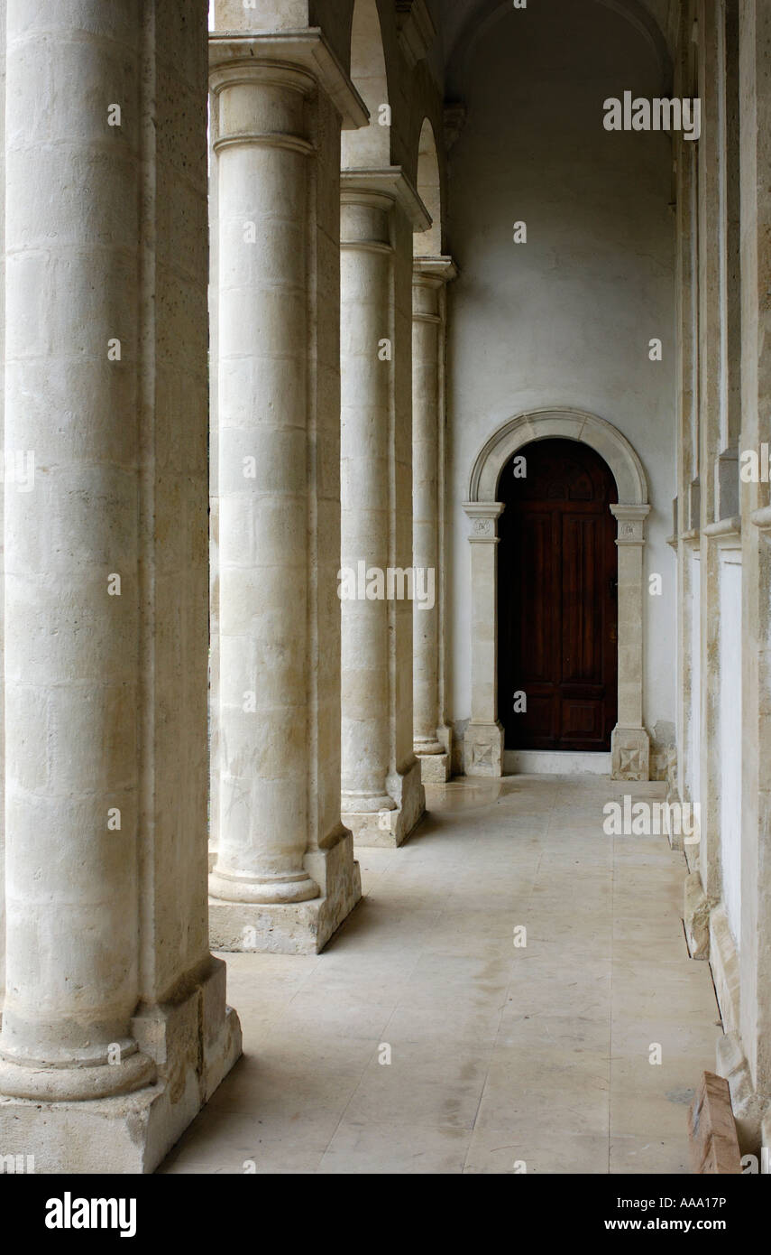 Arched hallway behind columns leading to a door Stock Photo - Alamy