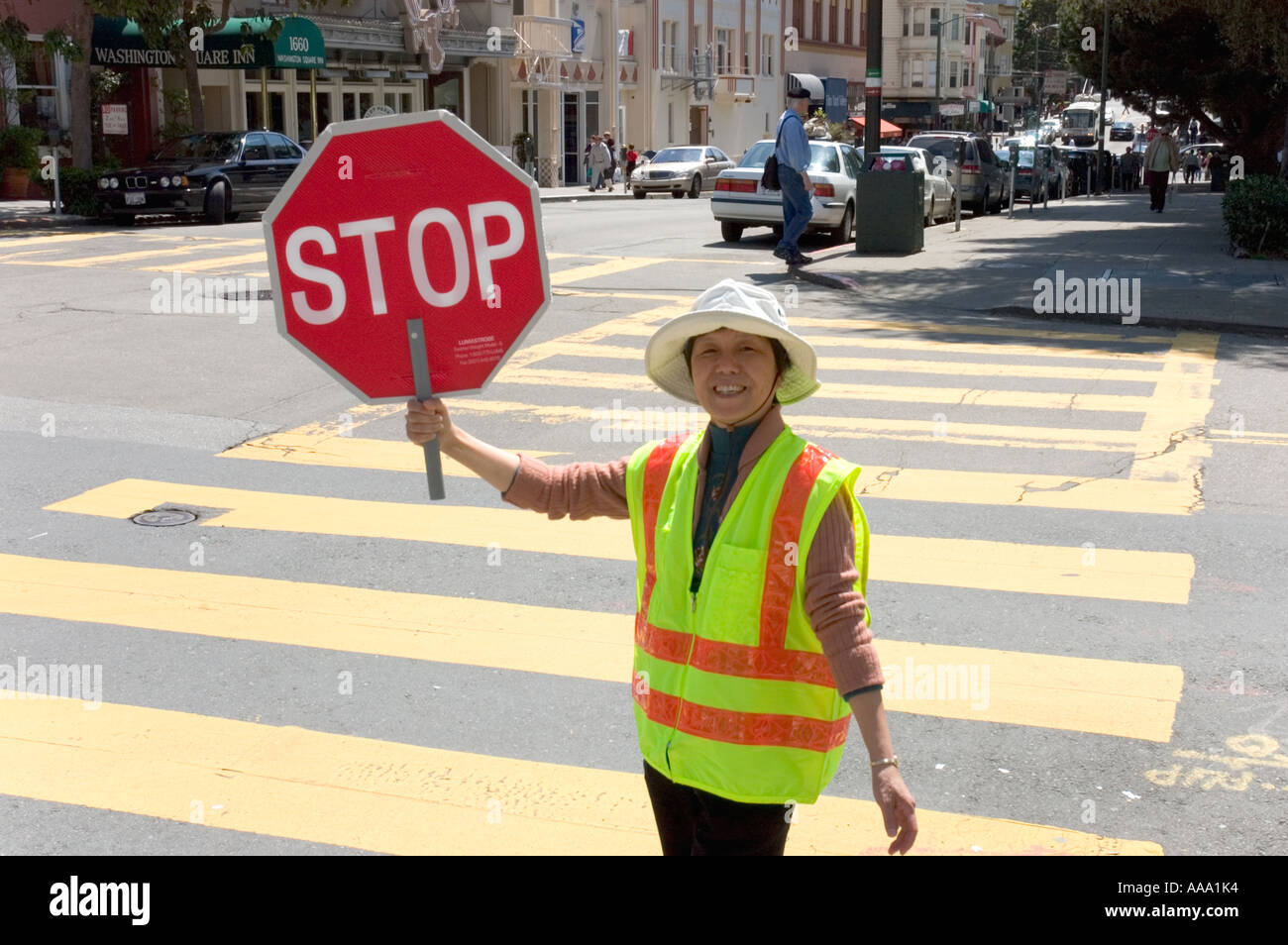 A female crossing guard in San Francisco wears a high-visibility yellow ...