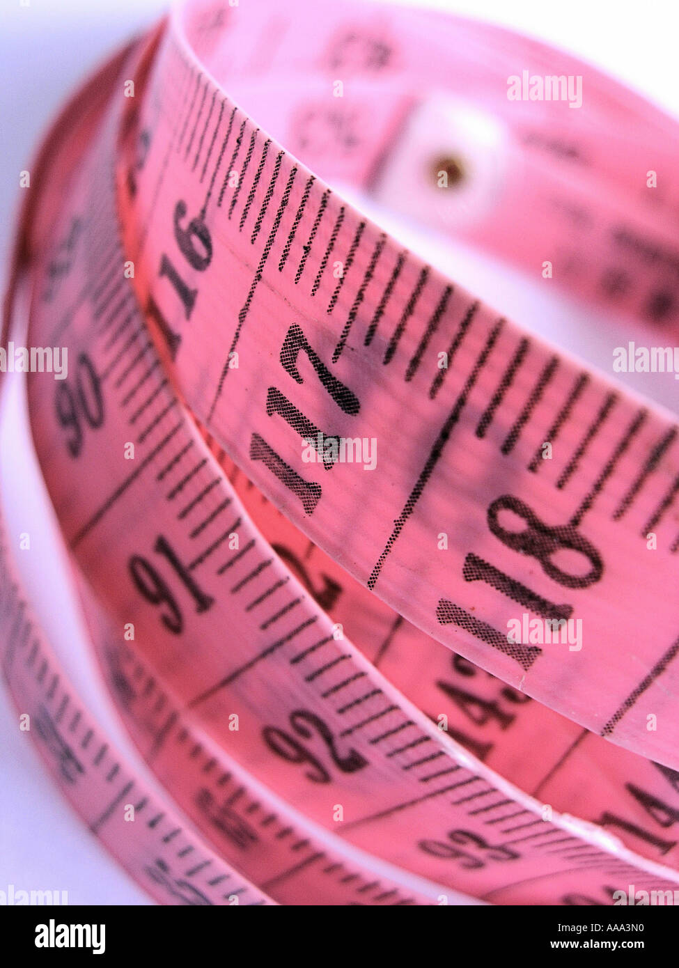 Pink tape measure gently rolled up showing numbers Stock Photo - Alamy