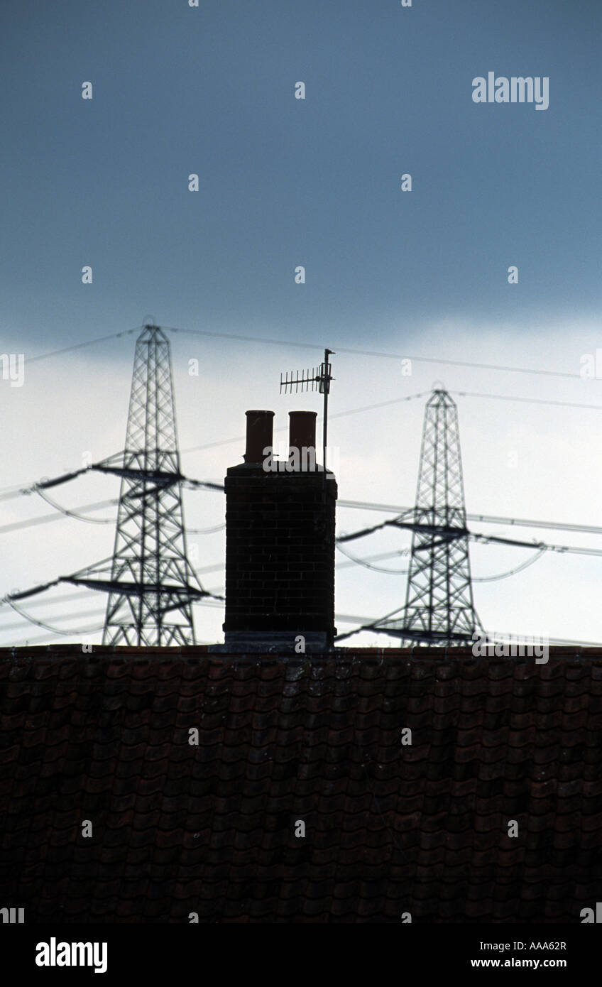Chimney stack of a house with high voltage electricity pylons from the ...