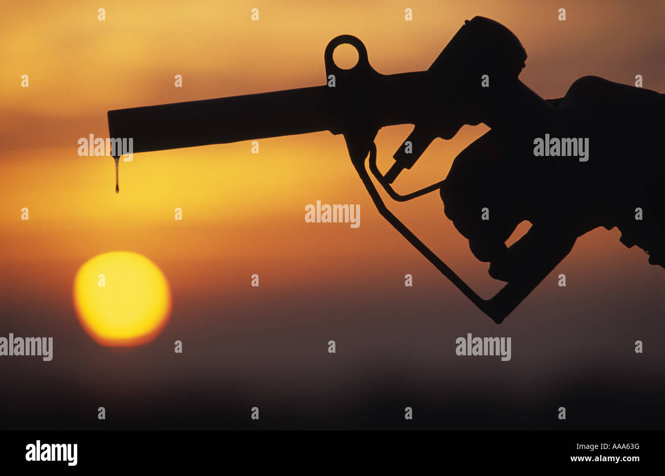 Drop of petrol running out of the end of pump at sunrise Stock Photo ...