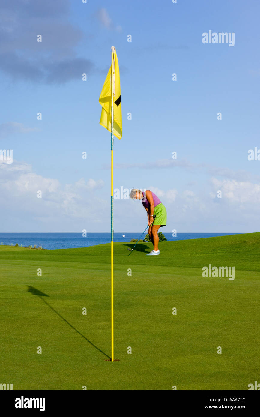 Senior woman. Putting at exotic golf course at the ocean Stock Photo ...