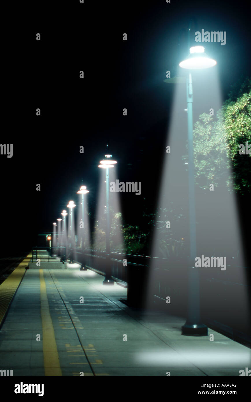 Walkway lit by glowing streetlamps Stock Photo - Alamy