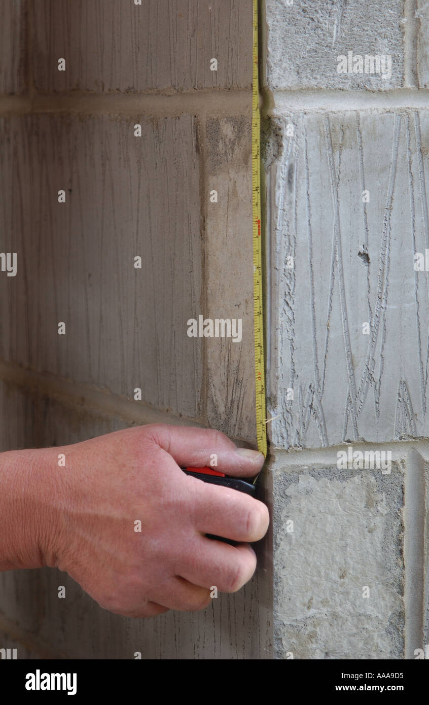 man measuring wall with tape measure Stock Photo - Alamy