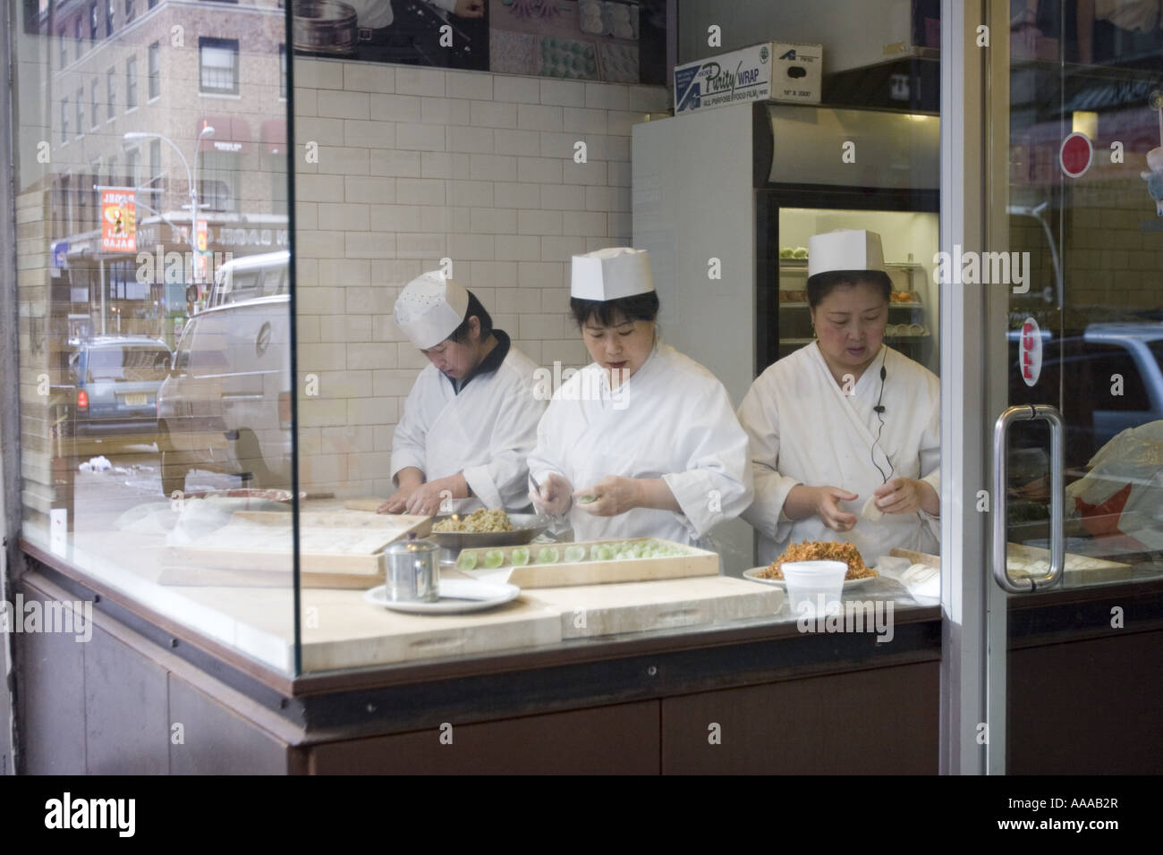 Food workers prepare Sushi in the window of a New York City restaurant ...