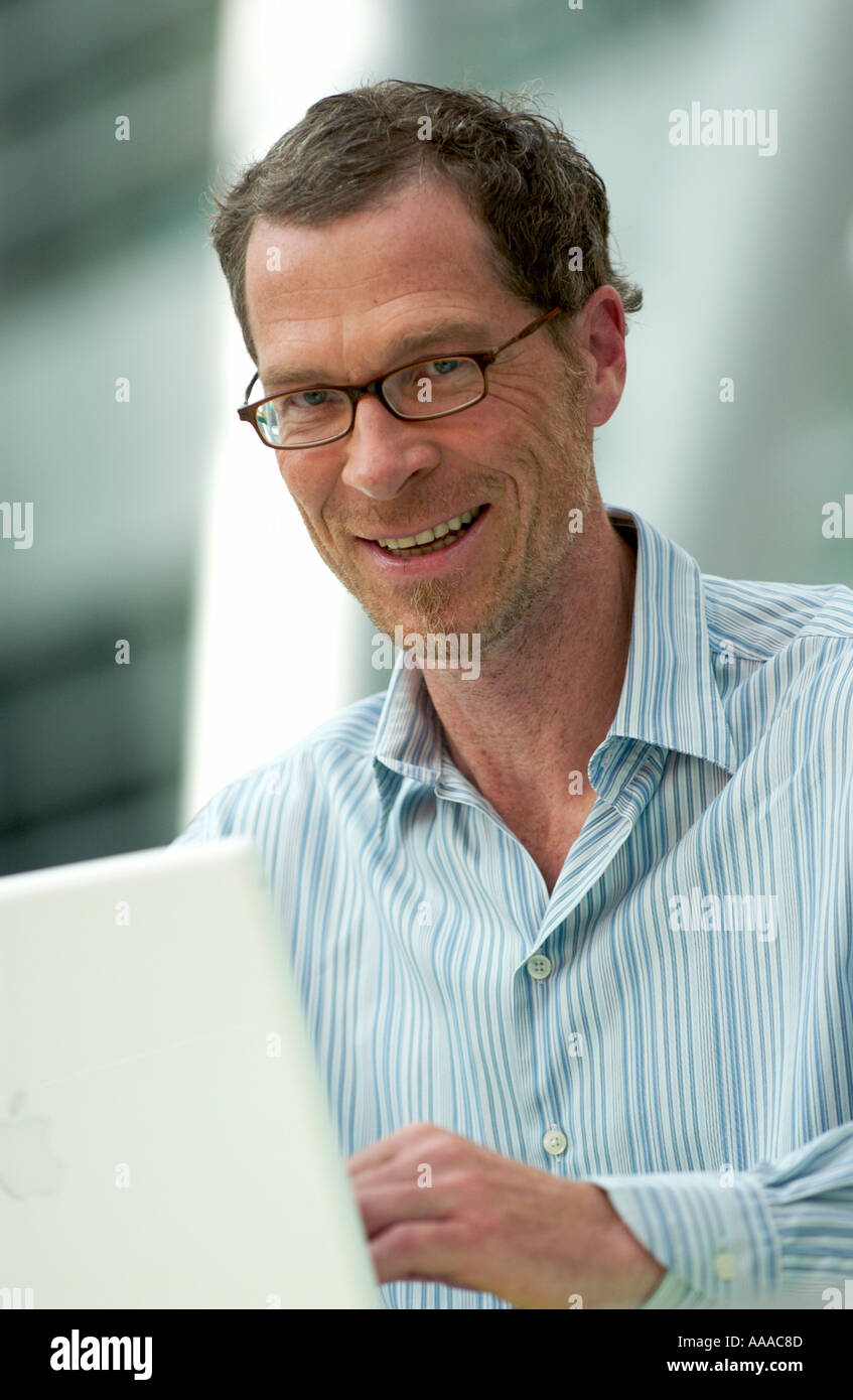 forty year old man working on laptop computer in the lobby of an ...